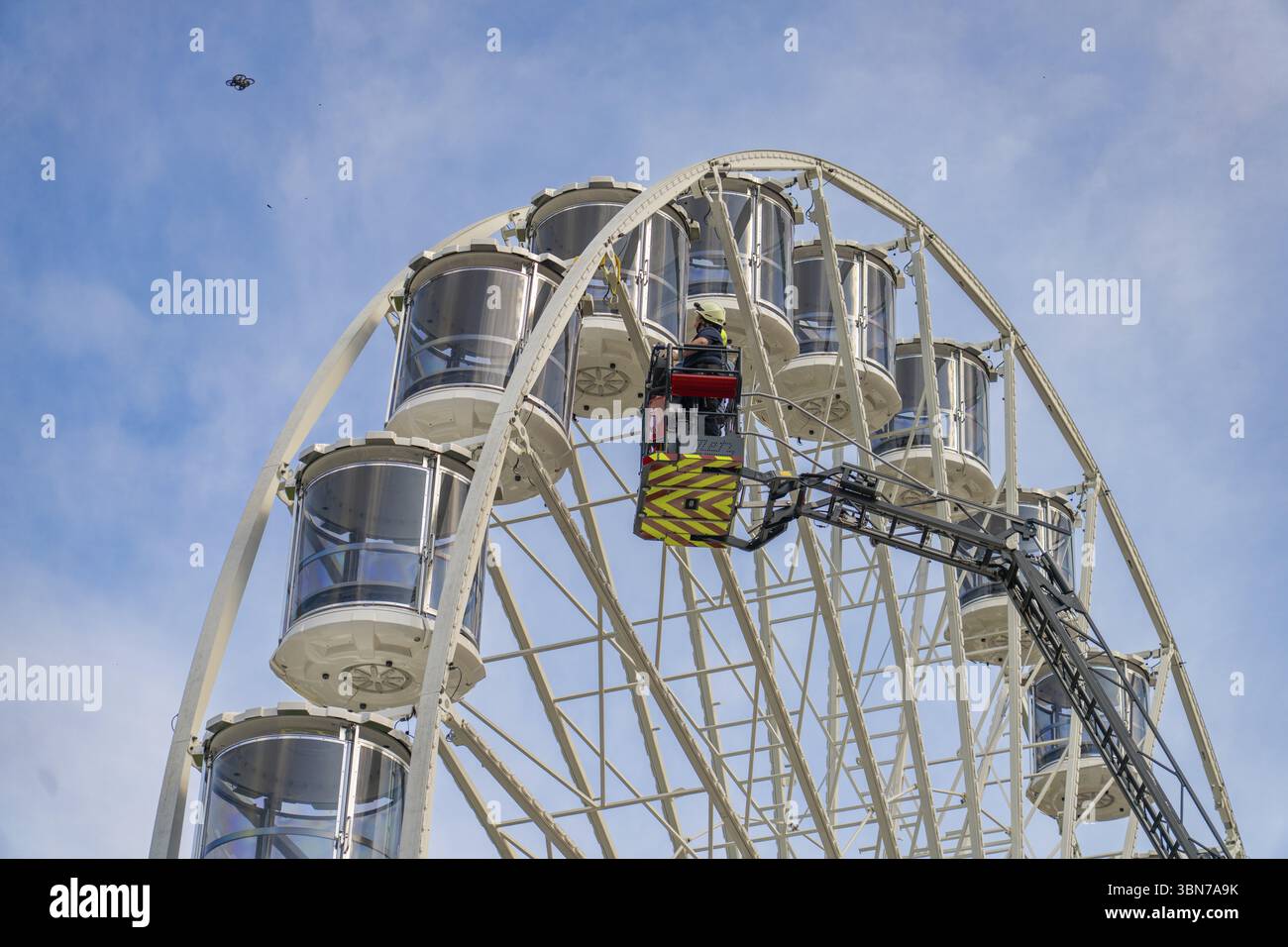 Firefighter in the rescue cage near the cabins of the Ferris wheel in ...