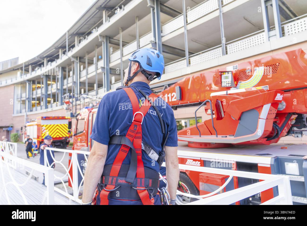 Fire brigade employee with protective helmet looking at a red fire ...