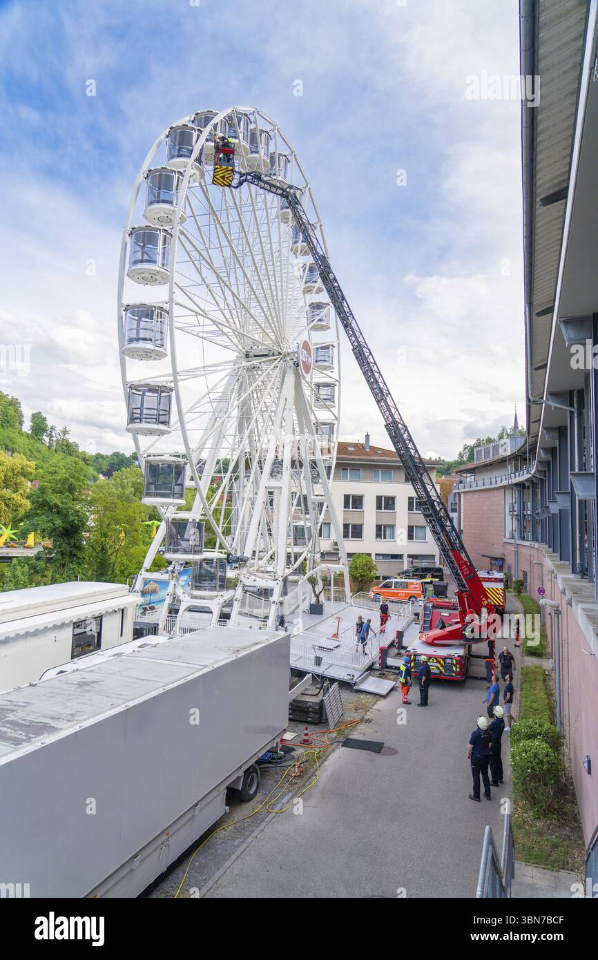 Fire brigade operation next to tall buildings with a Ferris wheel in ...