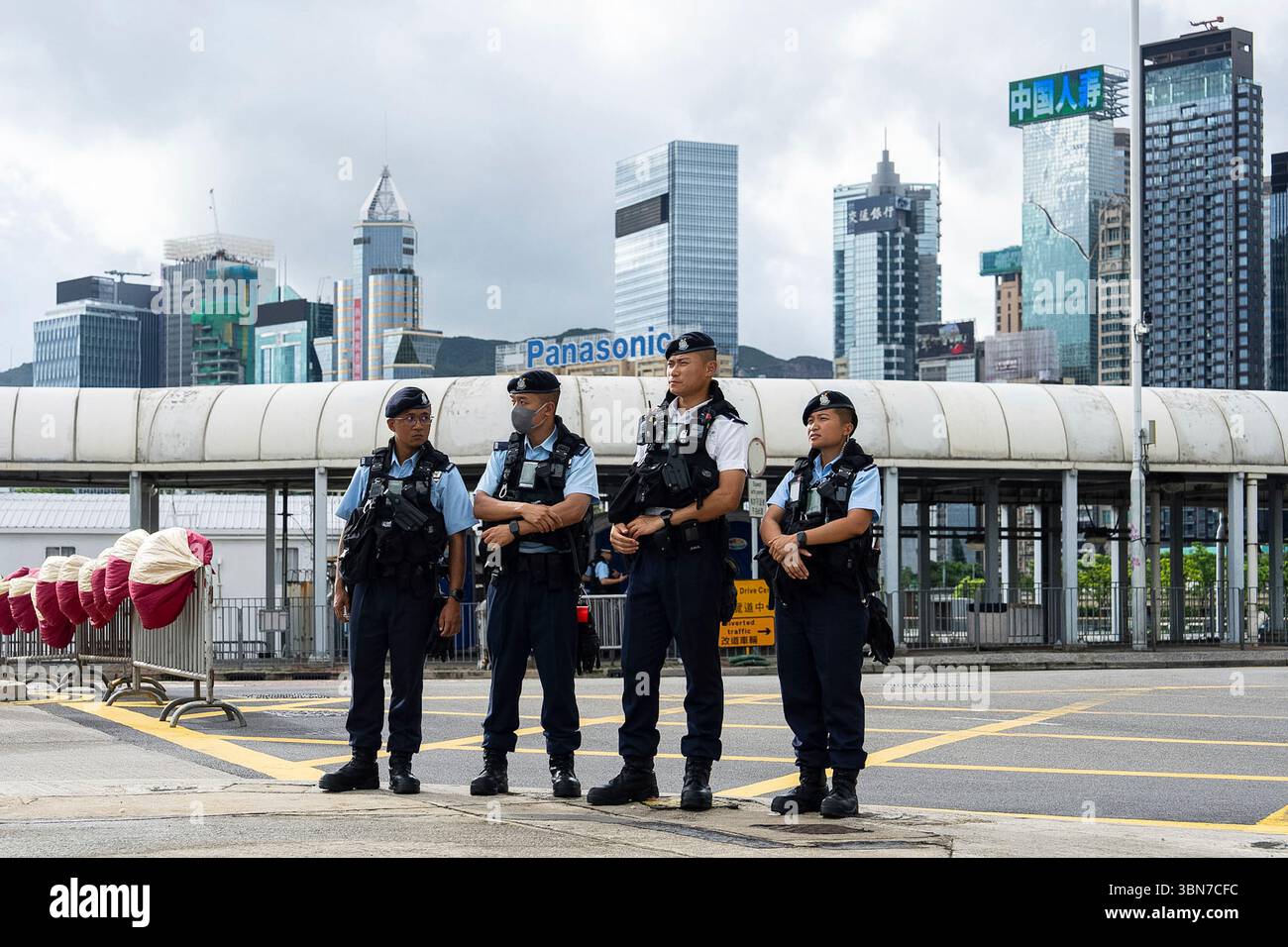 Police officers stand guard at a flag raising ceremony to mark the 28th ...