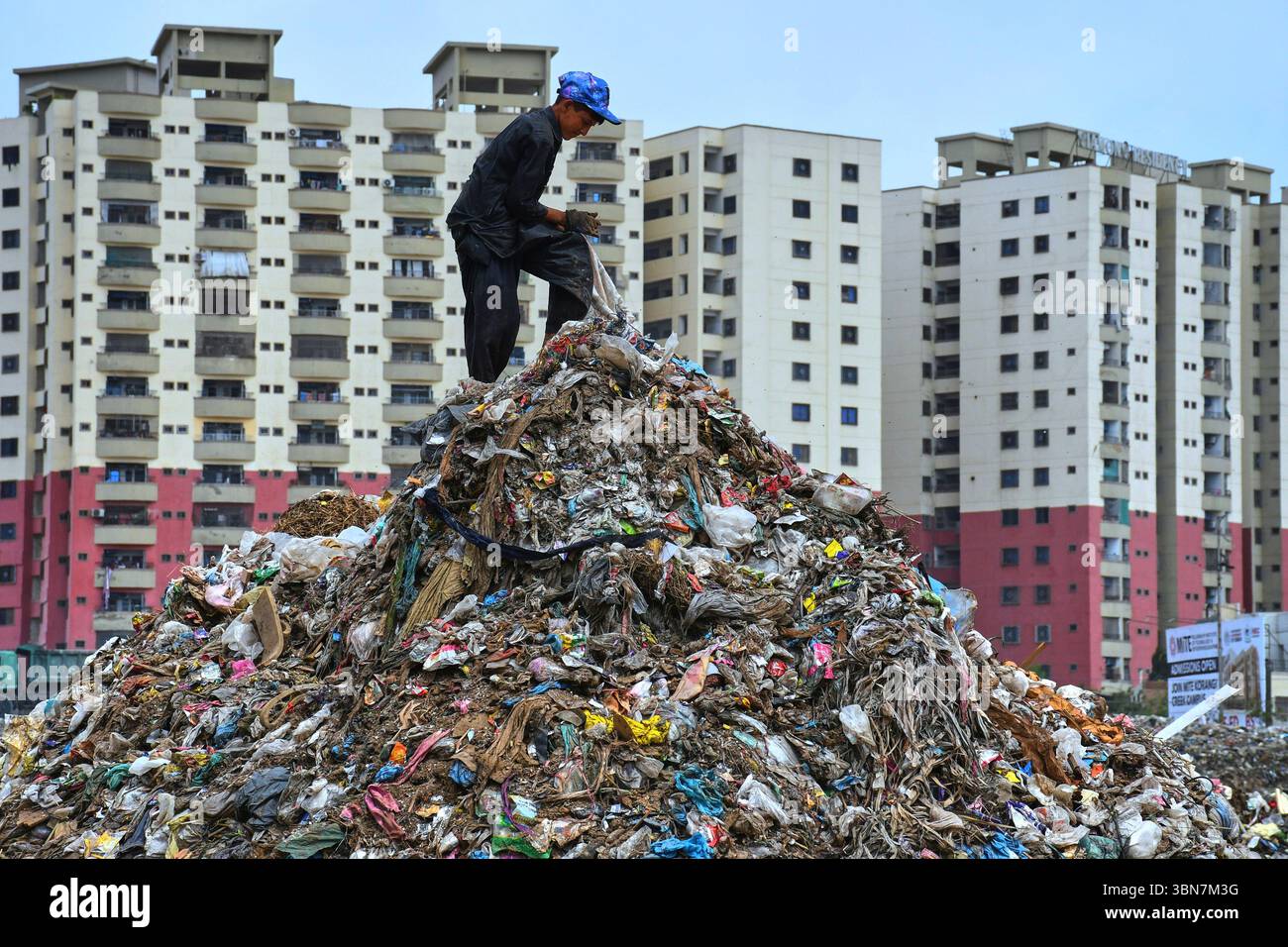 A boy searches for recyclable items from a pile of garbage at a dump ...