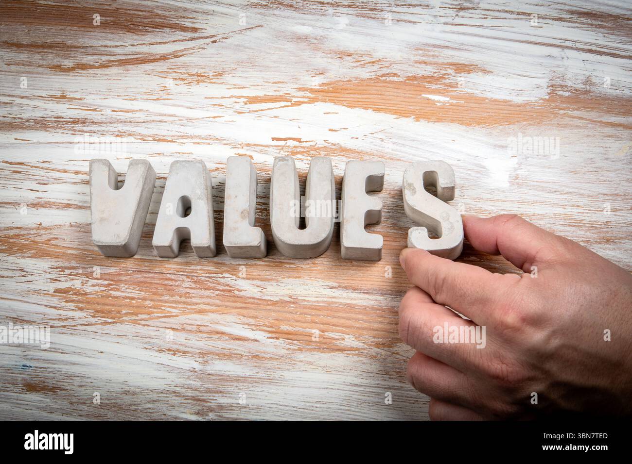 VALUES. Concrete alphabet letters on a light painted wood texture ...
