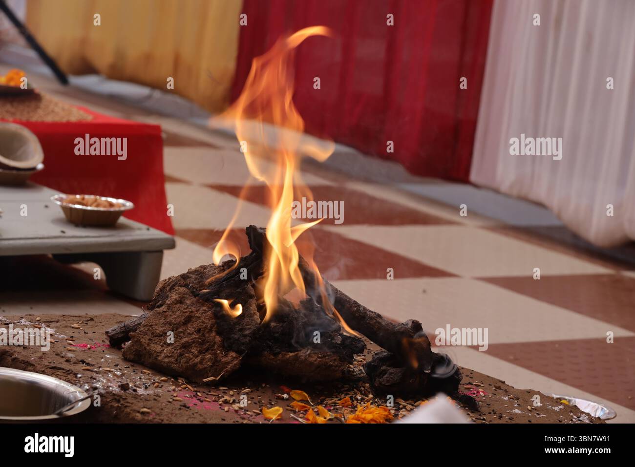 image shows a sacred fire (Agni) burning on a traditional setup, often ...