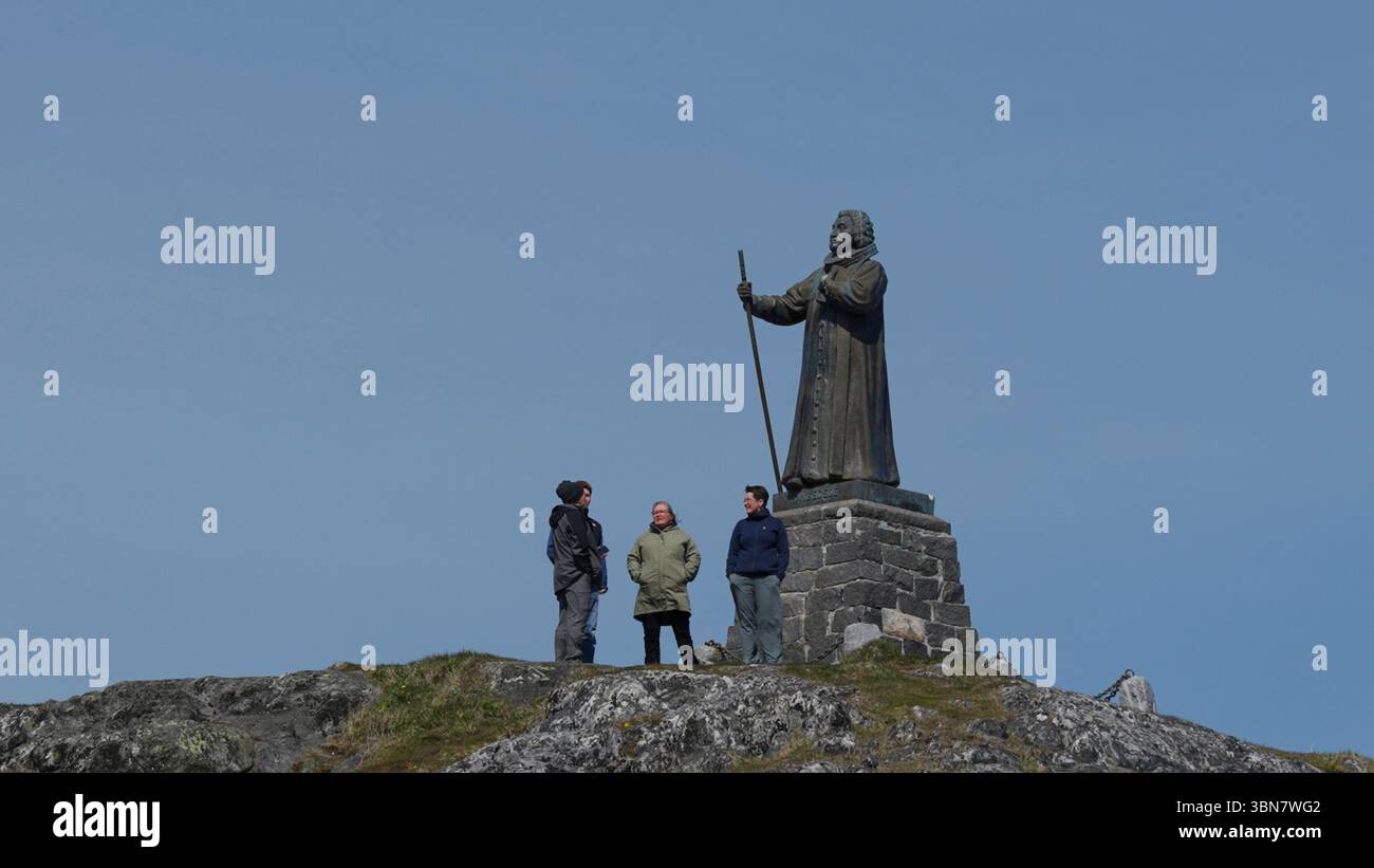 Tourists stand in front of the Statue of Hans Egede in Nuuk, Greenland ...