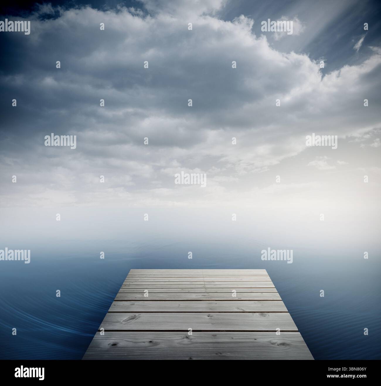 Wooden dock is extending into calm water, merging with misty horizon ...