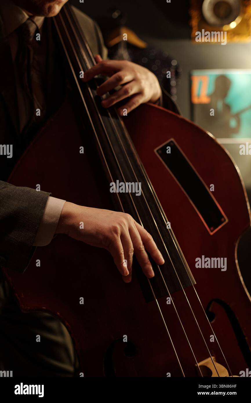 Caucasian middle aged man playing upright bass with focused hands on ...