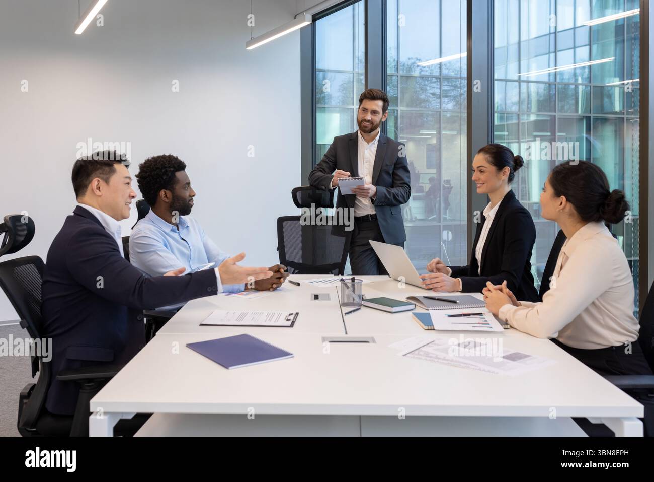 A diverse group of business professionals in a modern office setting ...