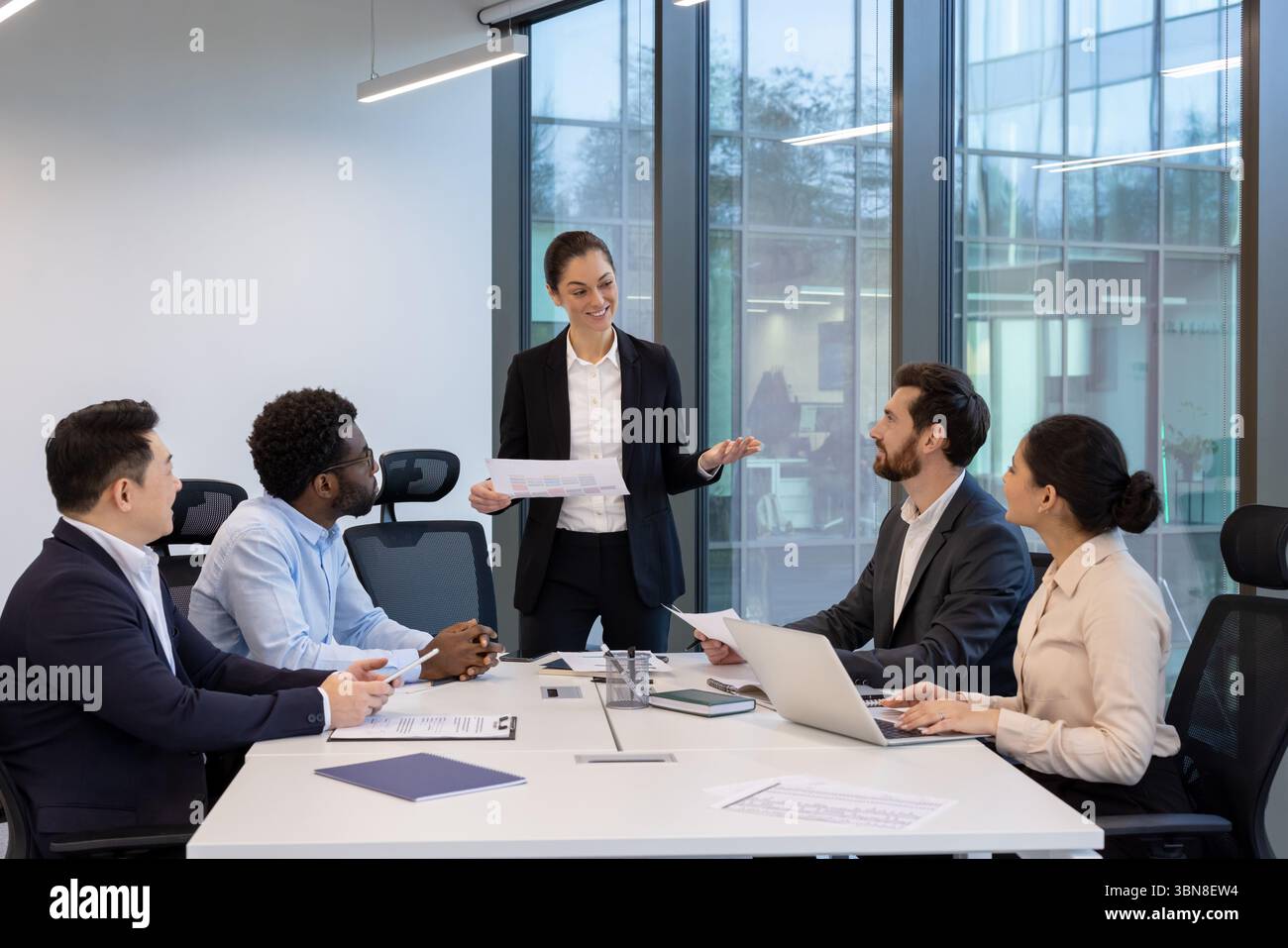 A diverse group of business professionals collaborating in a modern ...