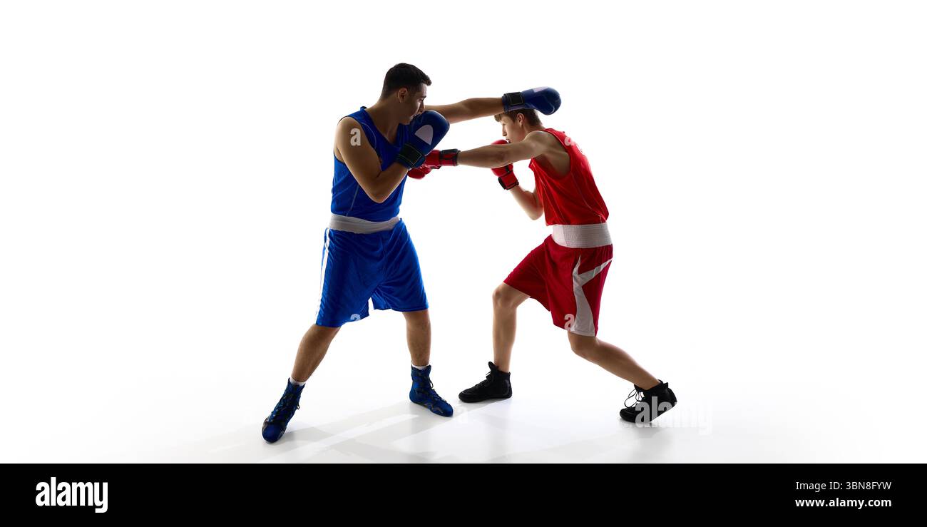 Two boxers engaged in competitive bout wearing contrasting red and blue ...
