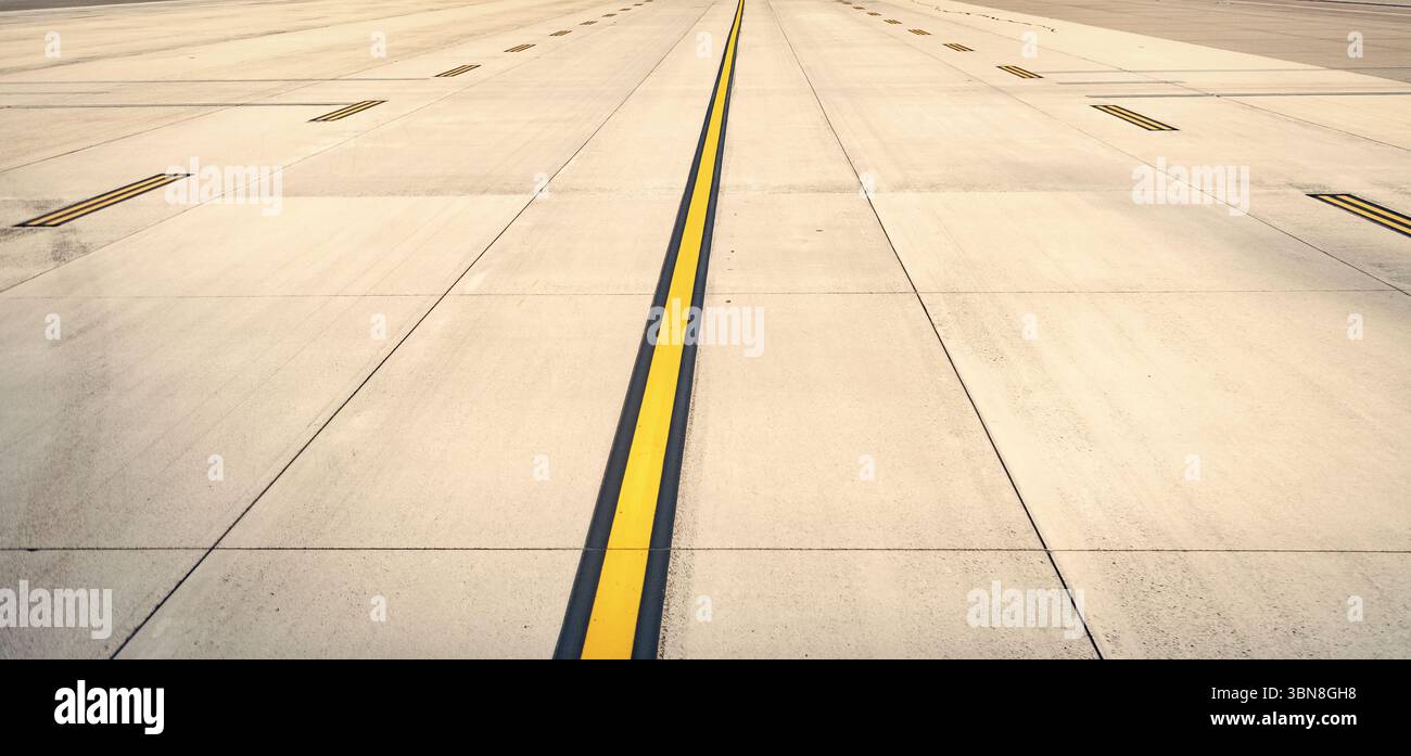 Airport runway. Surface level of long airport runway with yellow ...