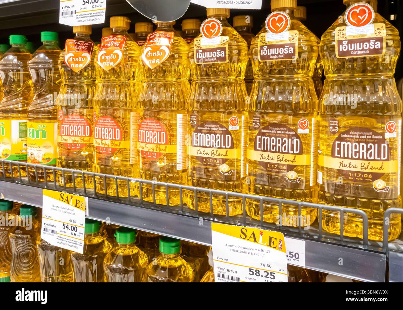shelf displays rows of vegetable oil bottles with "Emerald" labels ...