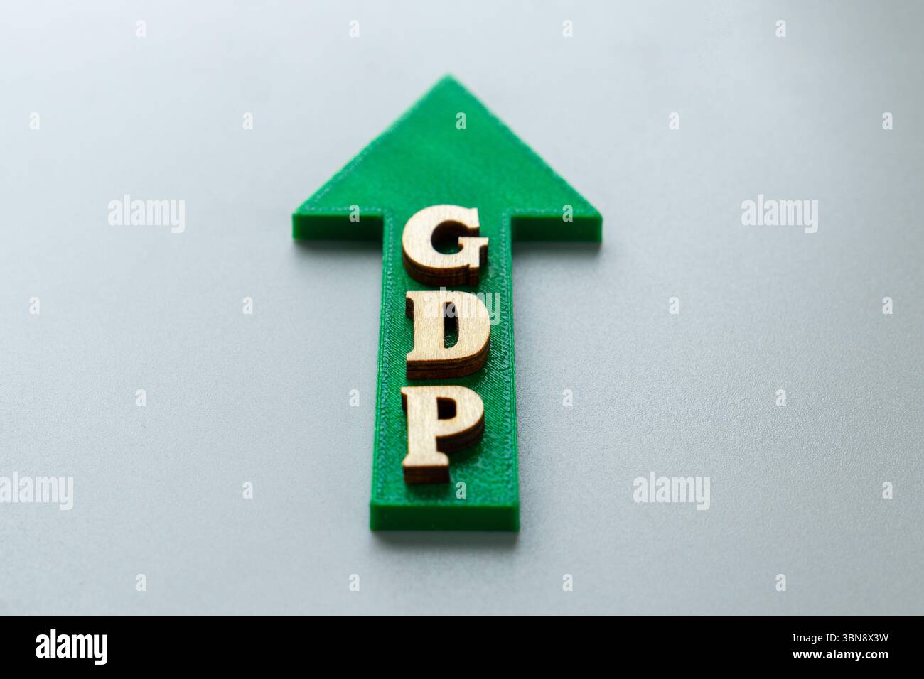 A green arrow points upwards, with wooden block letters spelling "GDP ...