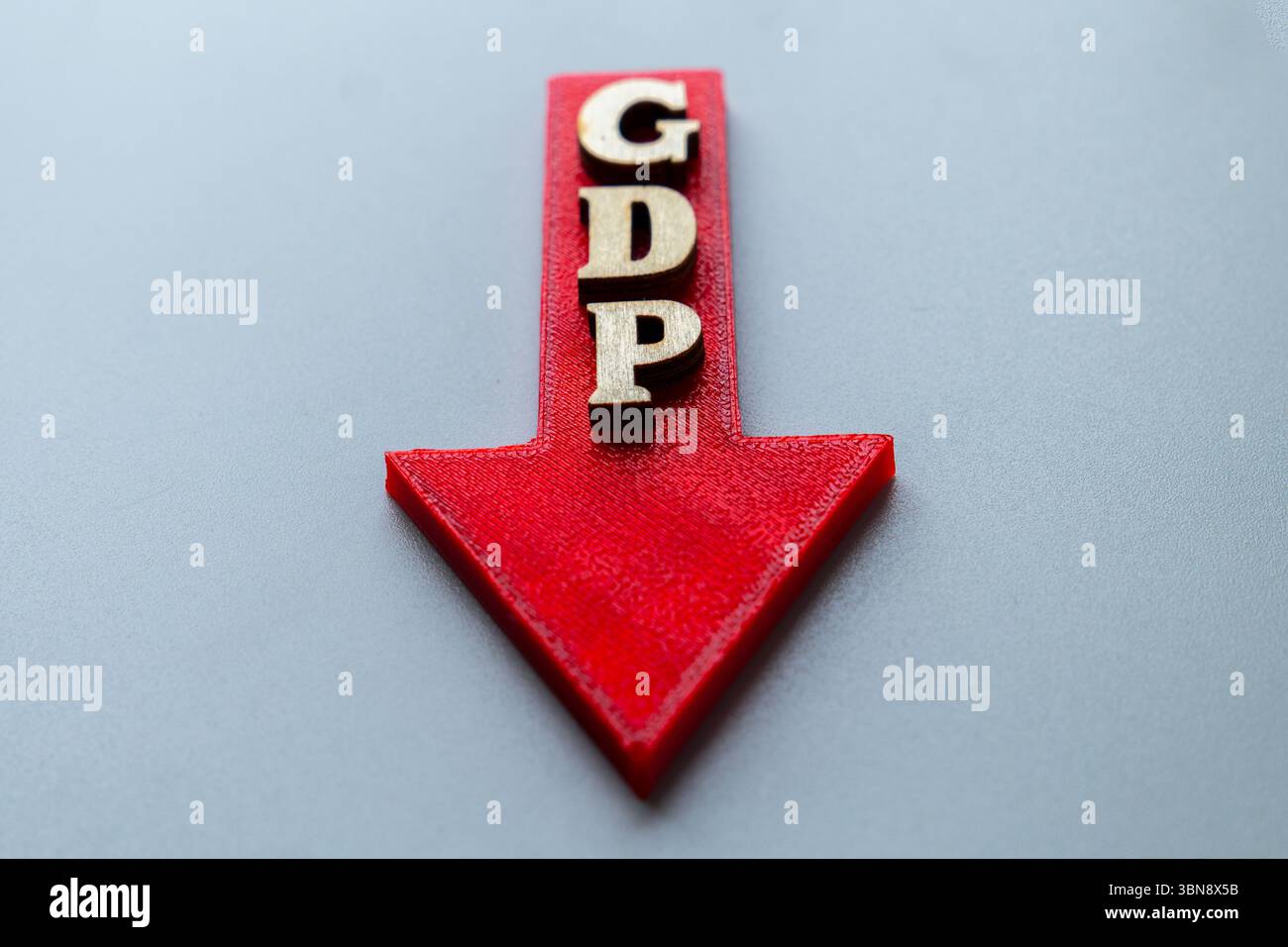 A red arrow points downwards, with wooden block letters spelling "GDP ...