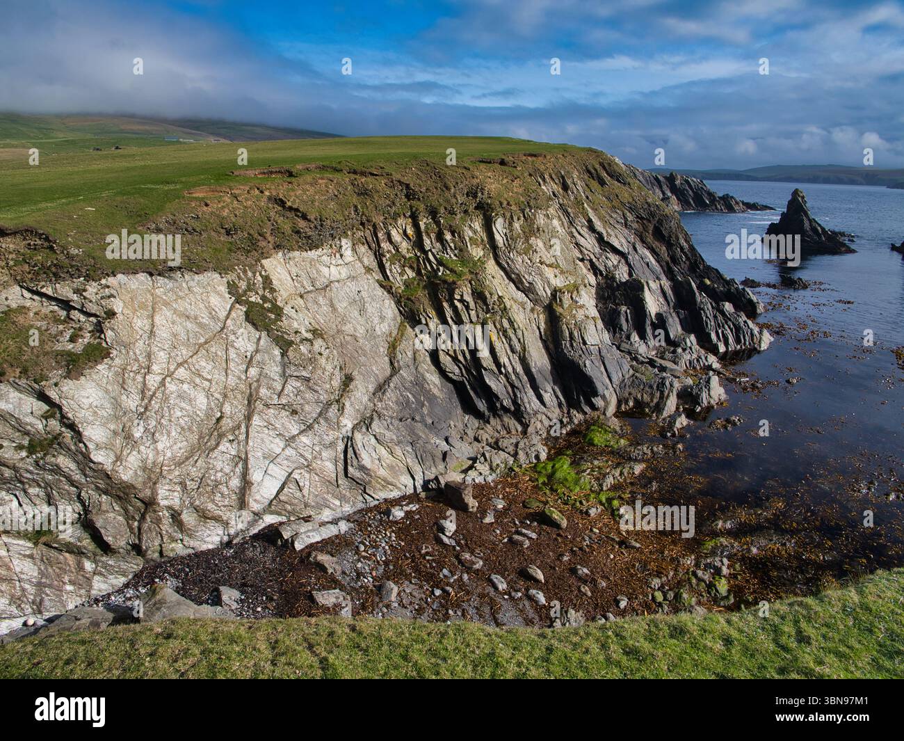 Rugged coastal cliffs meet the azure sea at St Ninian's Isle, Shetland ...