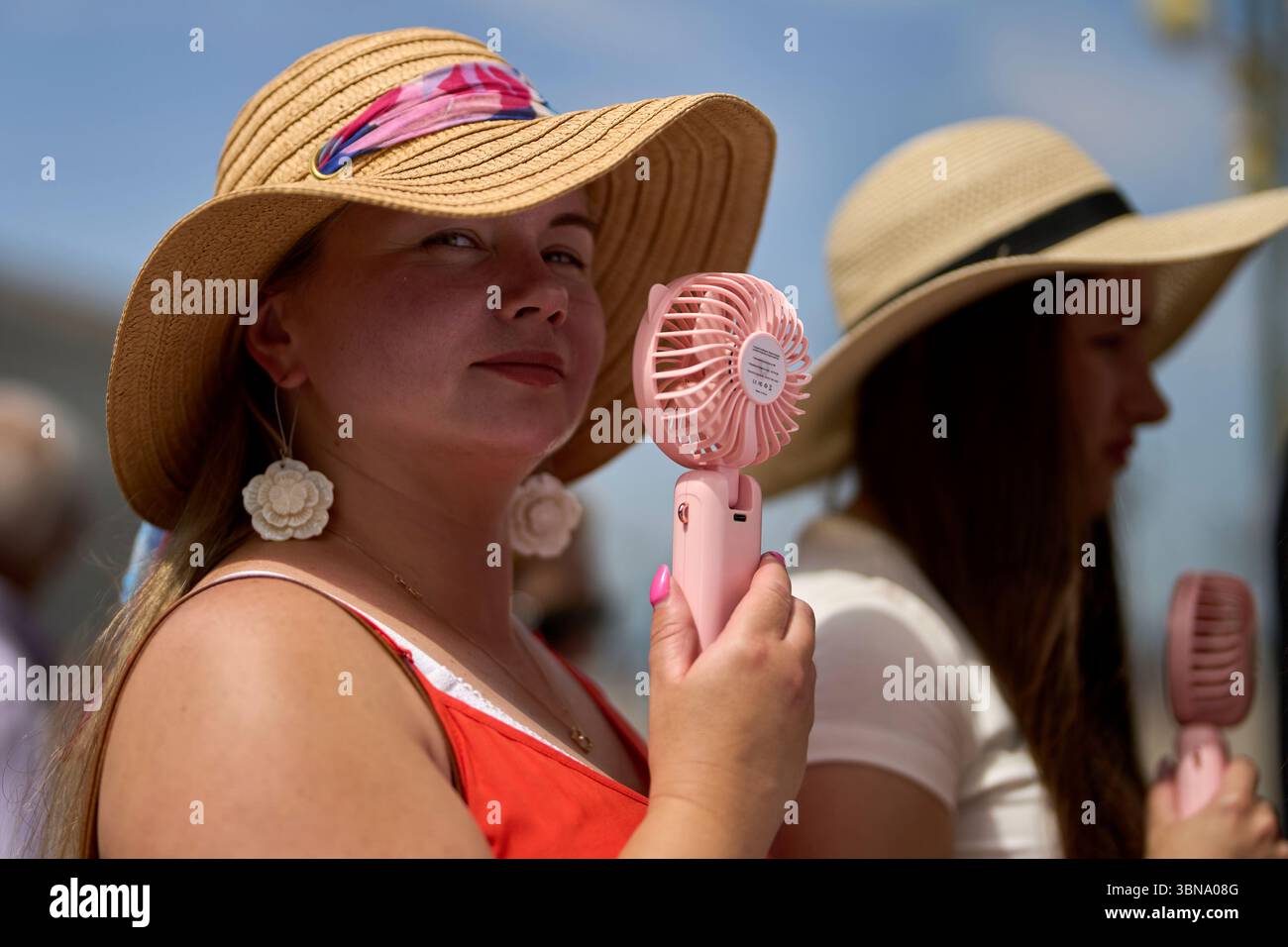 A woman cools herself with a handheld electric fan during a heat wave in Madrid, Spain, Tuesday ...
