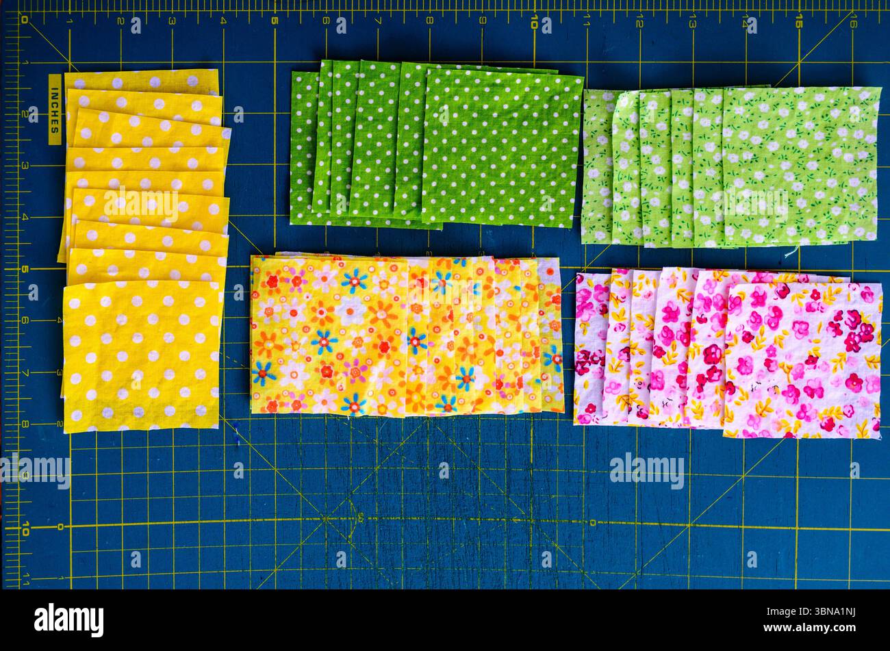 Above view of layered fabric squares for a quilt layering on a well ...