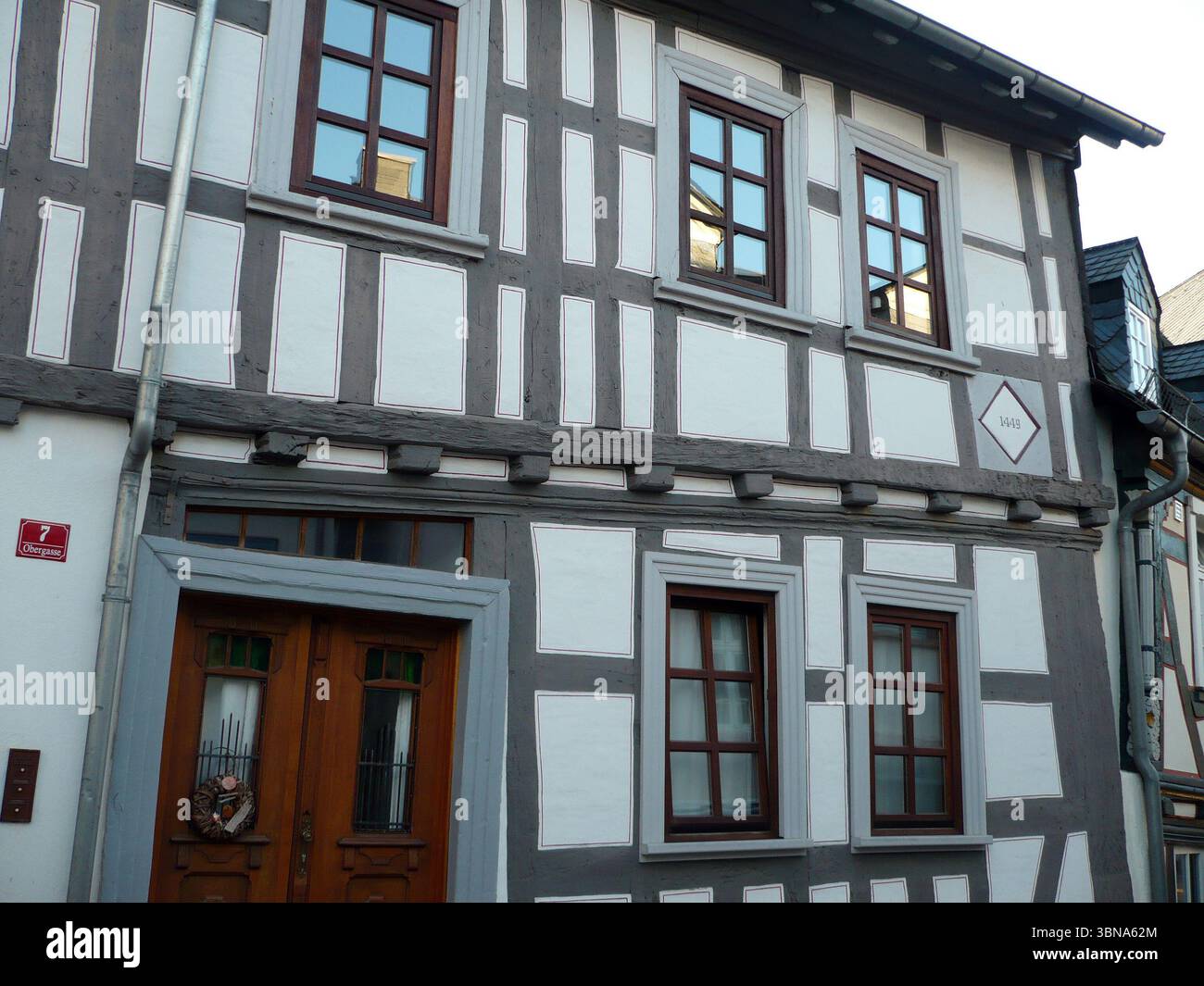 A traditional half-timbered house with a white exterior and dark gray ...