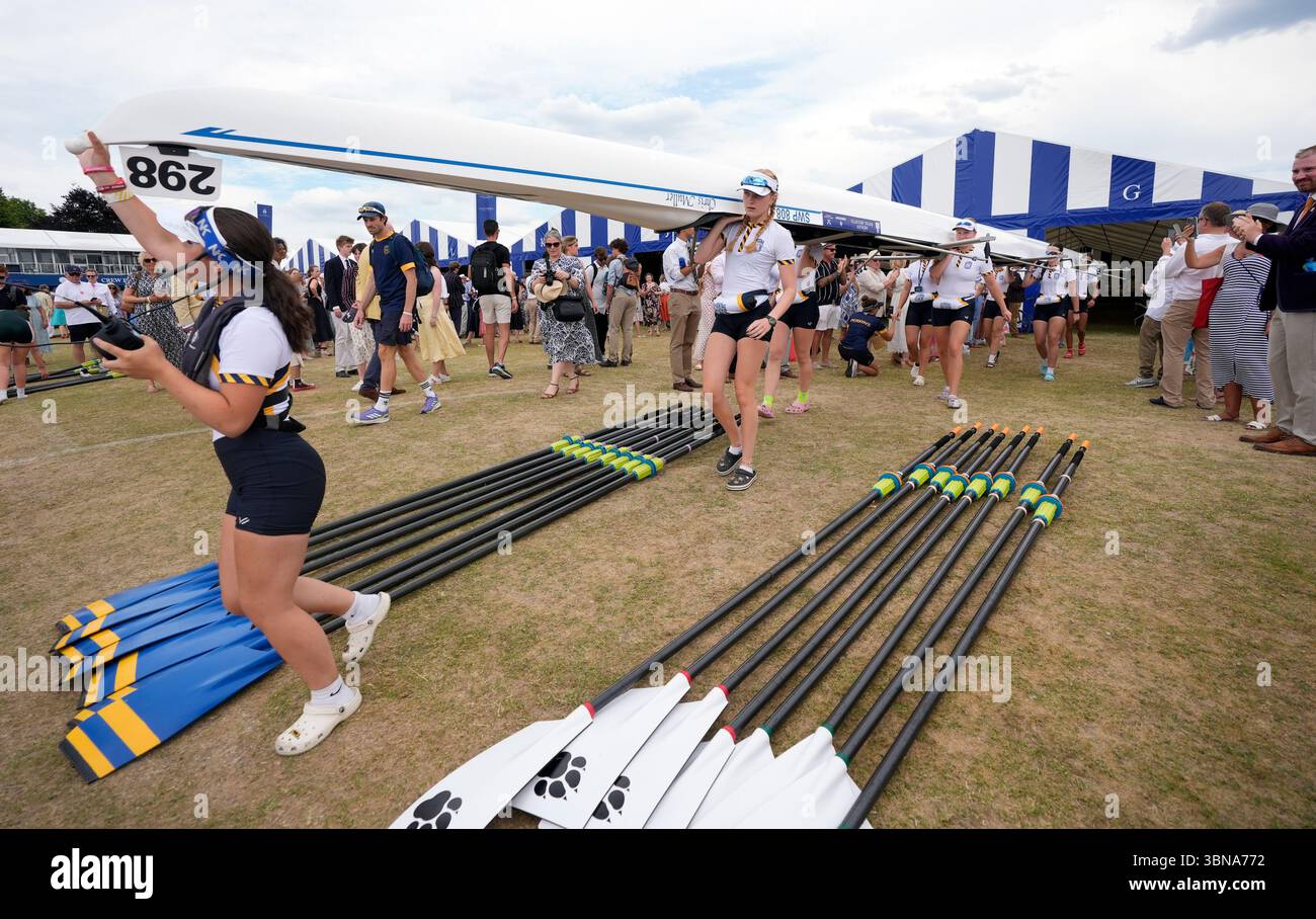 A rowing crew from Sir William Perkins's School carry their boat out of ...
