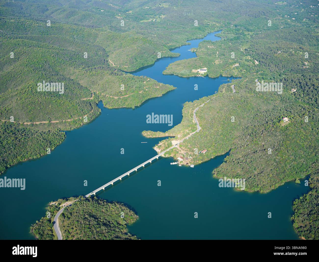 AERIAL VIEW. Reservoir surrounded by a landscape of dense vegetation in ...