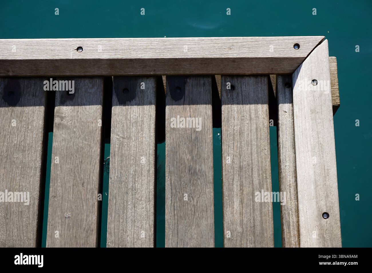 A close-up view of a wooden pier or dock. The pier is constructed from ...