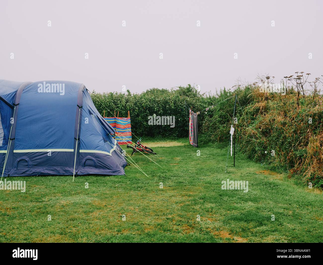 A tent windbreak and washing line on a cloudy wet day in the UK Stock ...