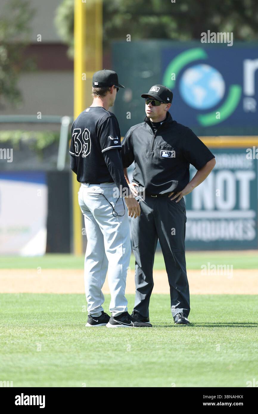 Umpire Christian Miranda talks with Manager Brian Burris (39) of the ...