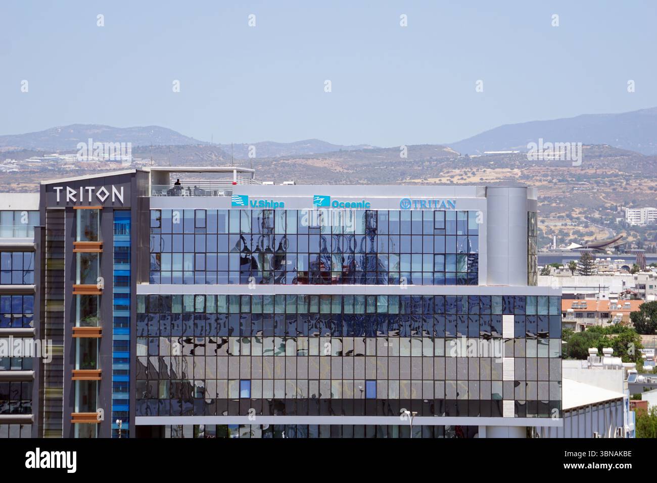 A modern, multi-story building with a glass facade and a white exterior ...