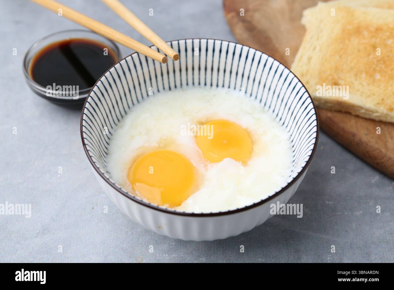Traditional asian breakfast with half-boiled eggs in bowl, soy sauce ...