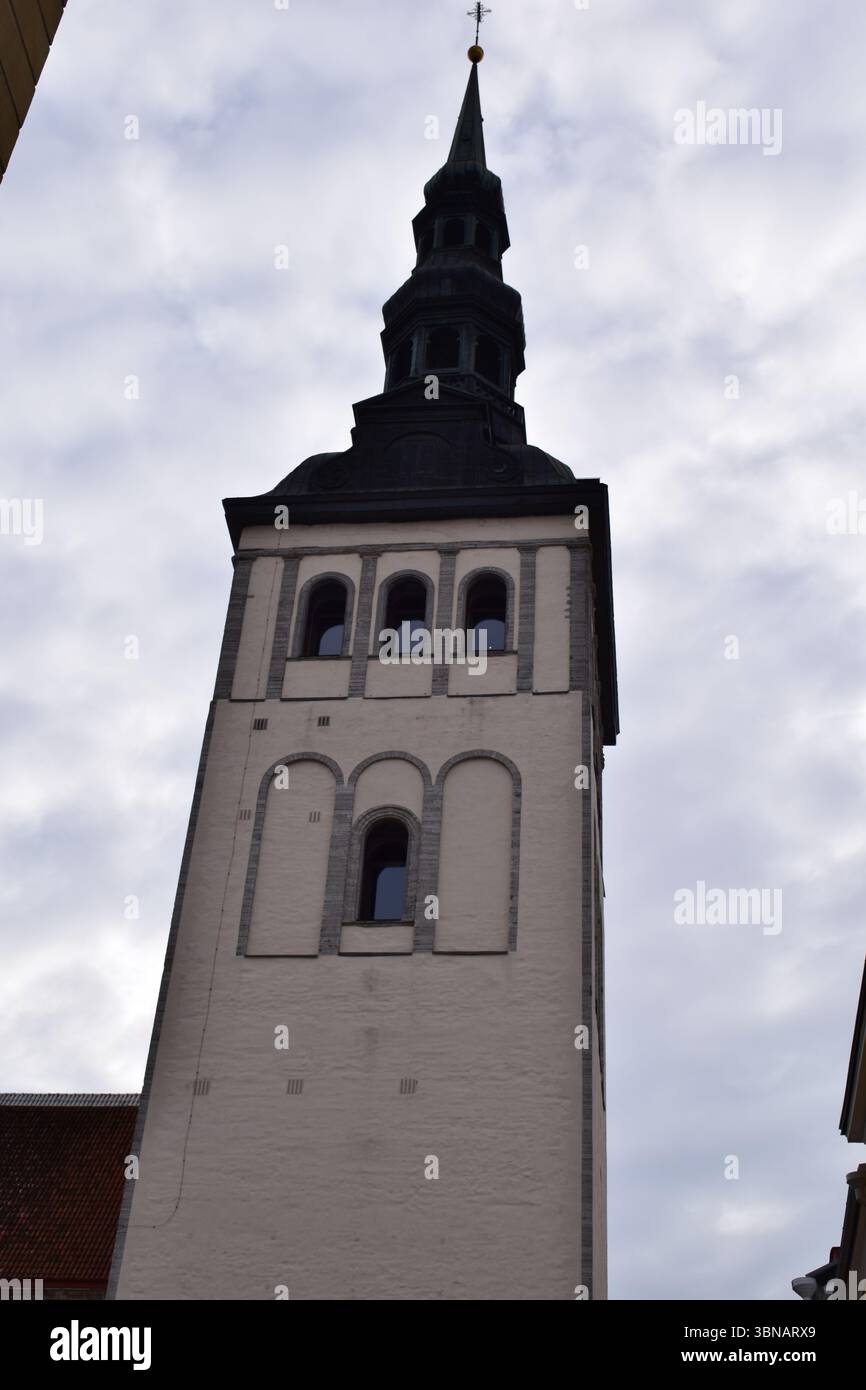Historic Church Tower with Spire Against Overcast Sky in Tallinn Stock ...