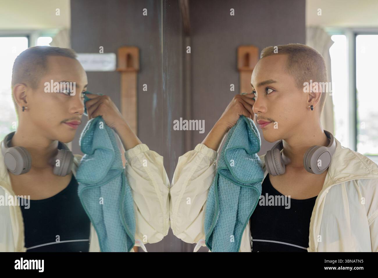Non-binary Asian person exercising in gym wearing sportswear Stock ...