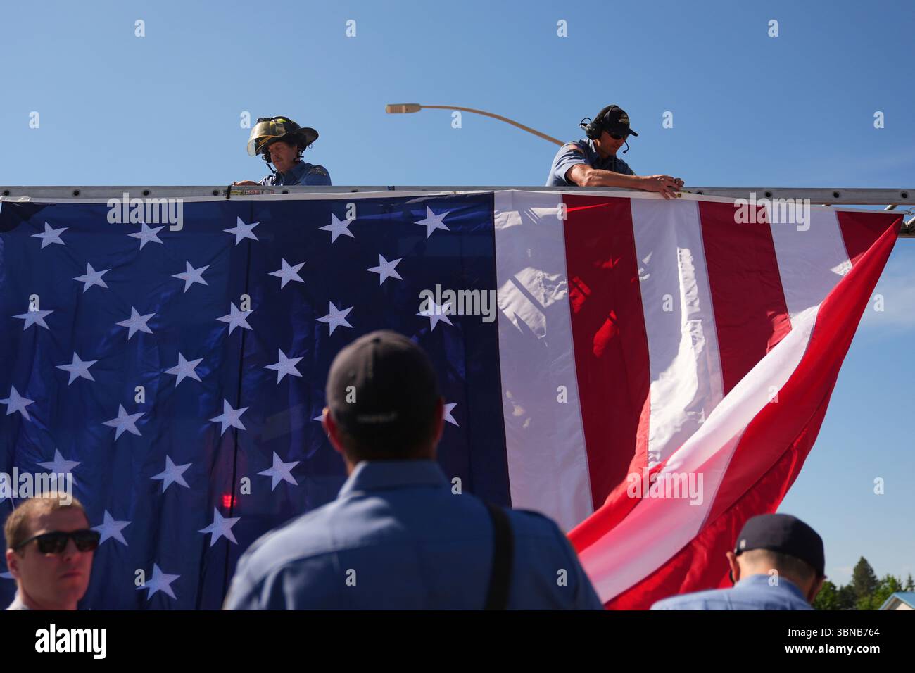 The Coeur d'Alene Fire Dept. hangs an American flag to honor the ...
