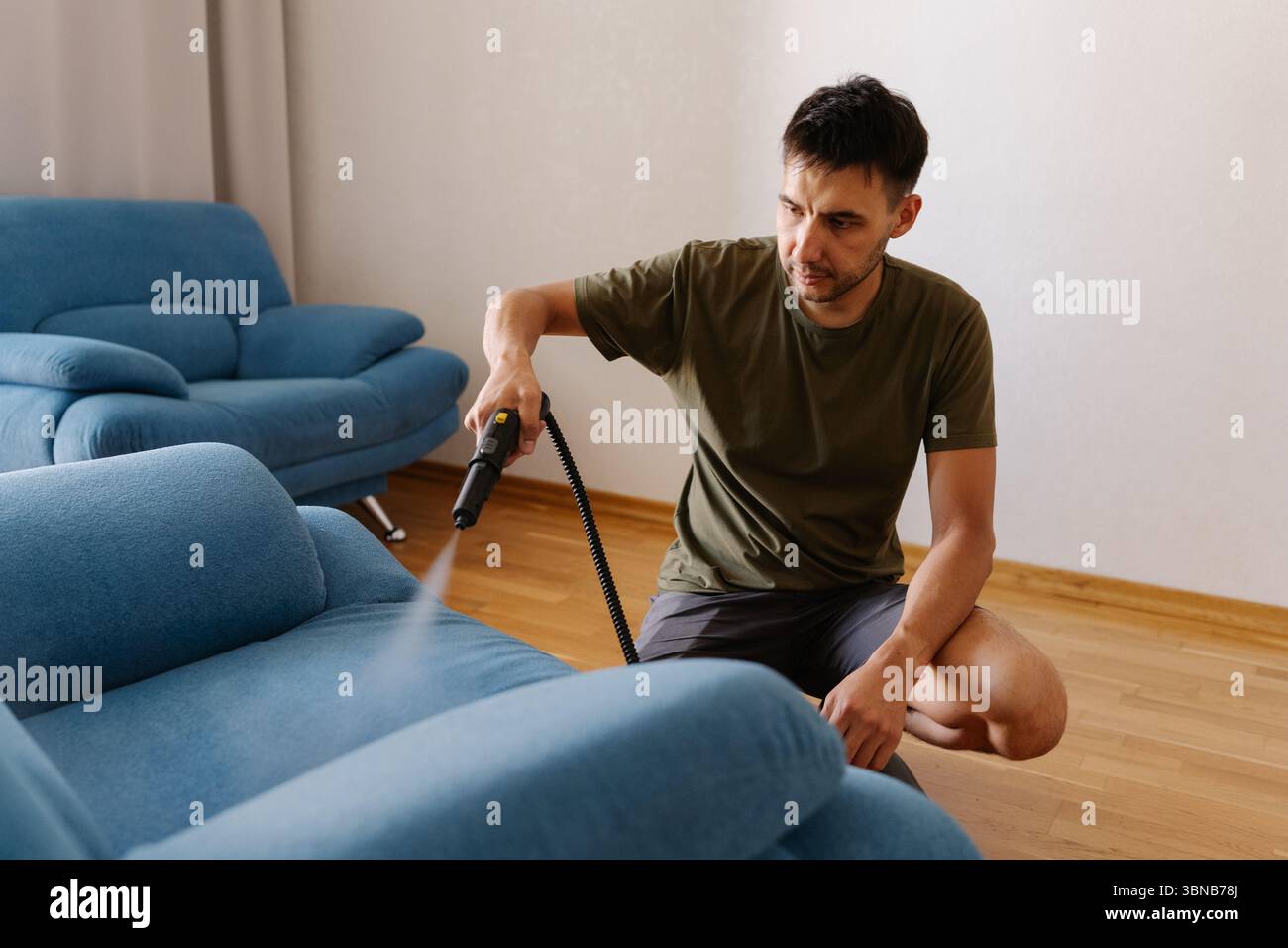Professional cleaning service worker using steam cleaner to remove dirt ...