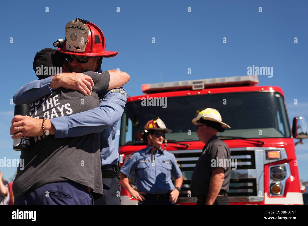 Chris Kieres, captain with Couer d'Alene Fire Dept.,gets a hug, as a ...