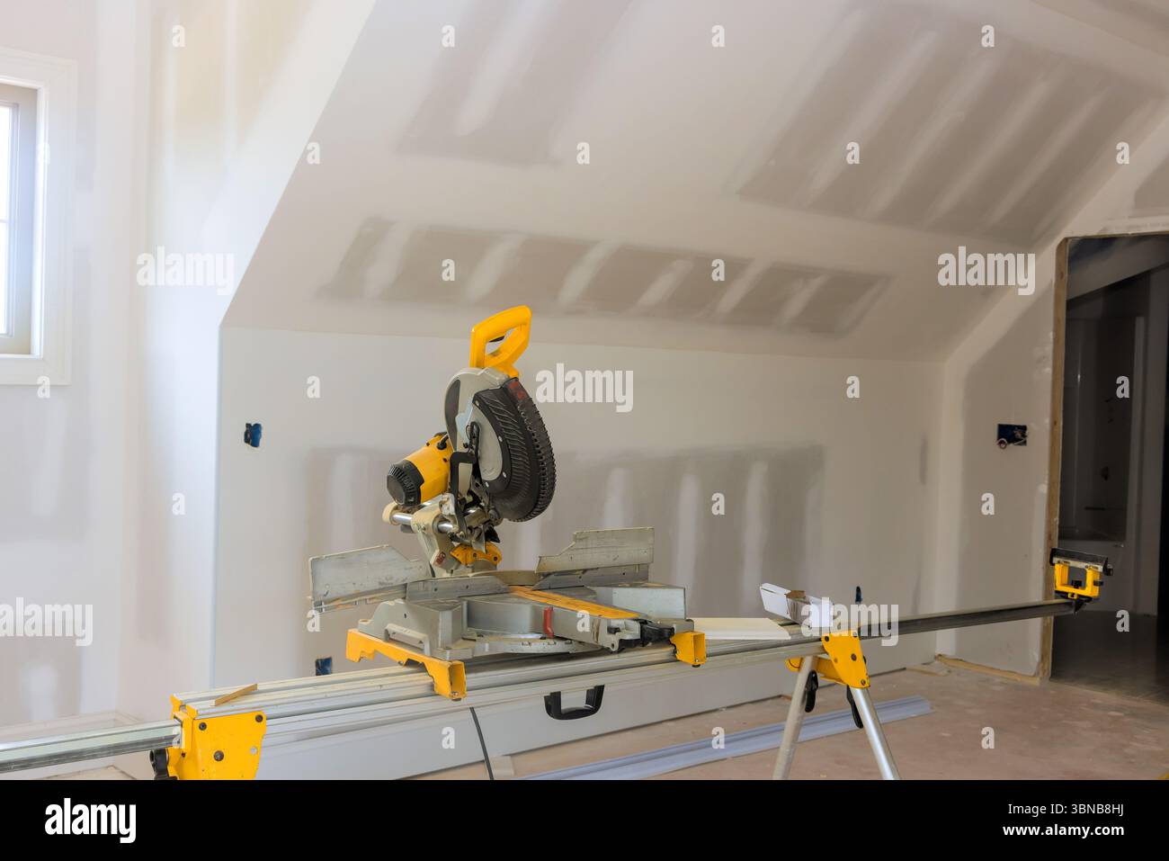 Circular saw sits on stand, surrounded by drywall as workers prepare ...