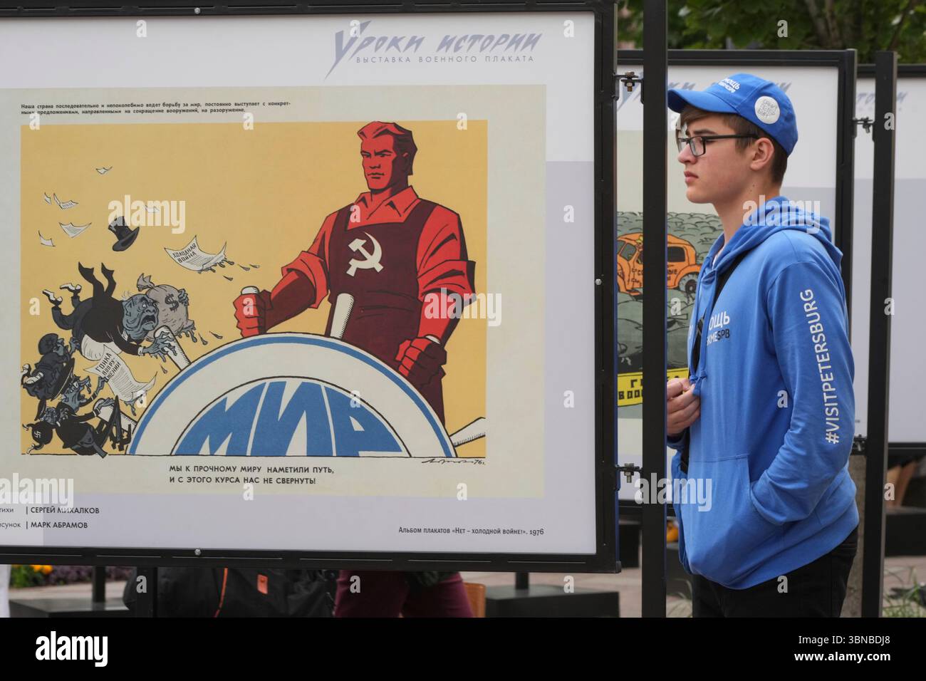 A boy looks at a poster at a street exhibition of the Soviet-era war ...