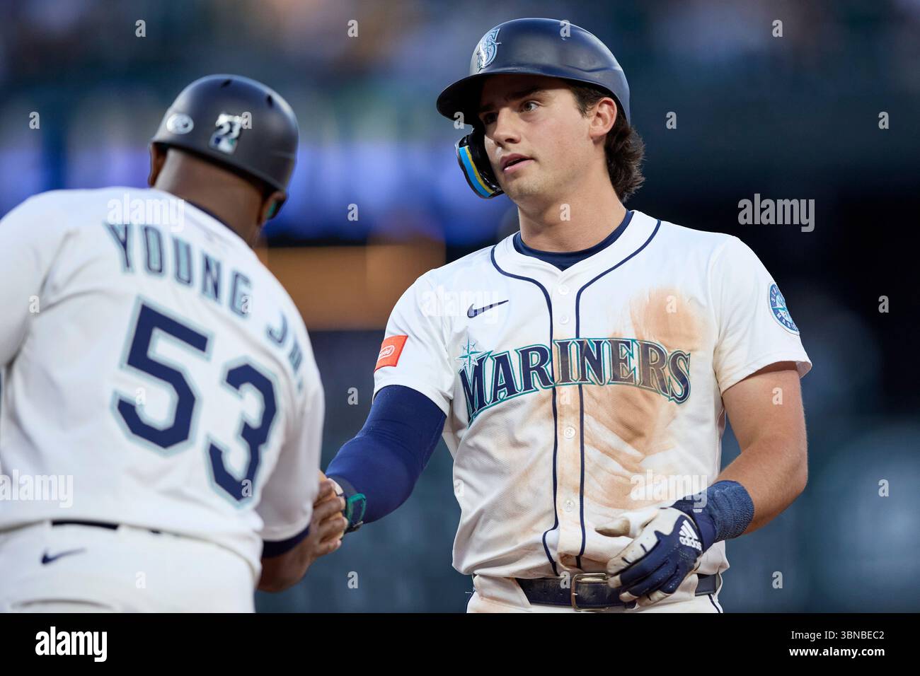 Seattle Mariners' Cole Young is greeted by first base coach Eric Young ...
