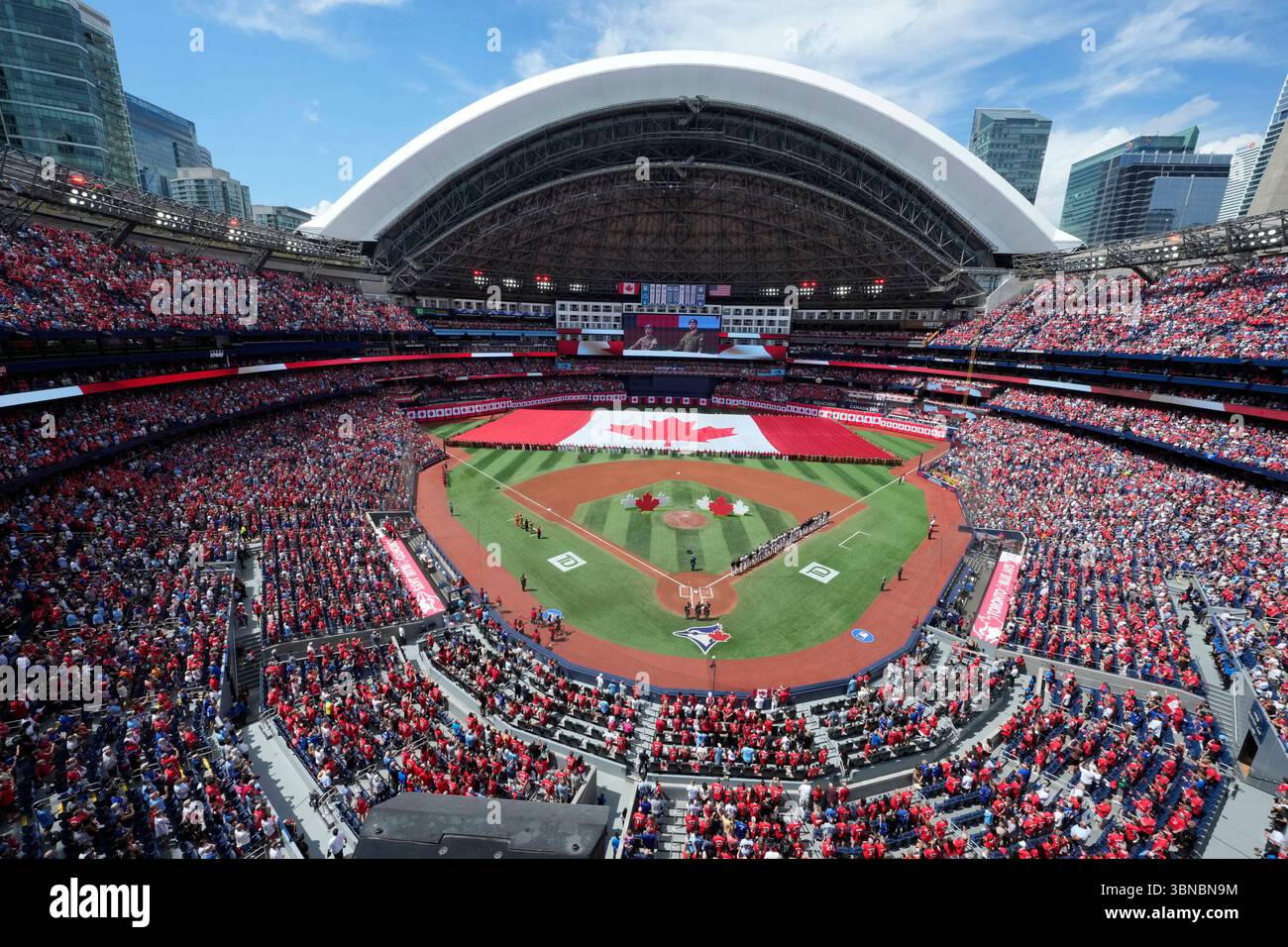 A large Canadian flag is unfurled before the start of a baseball game ...