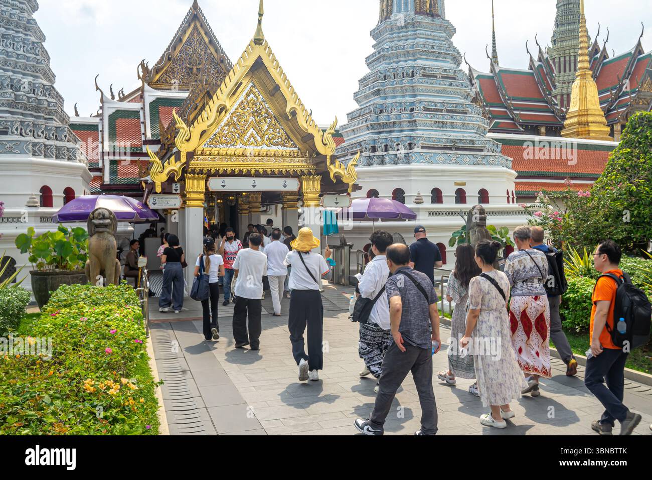 Tourists entering a historic Grand Palace, Royal Palace complex in ...