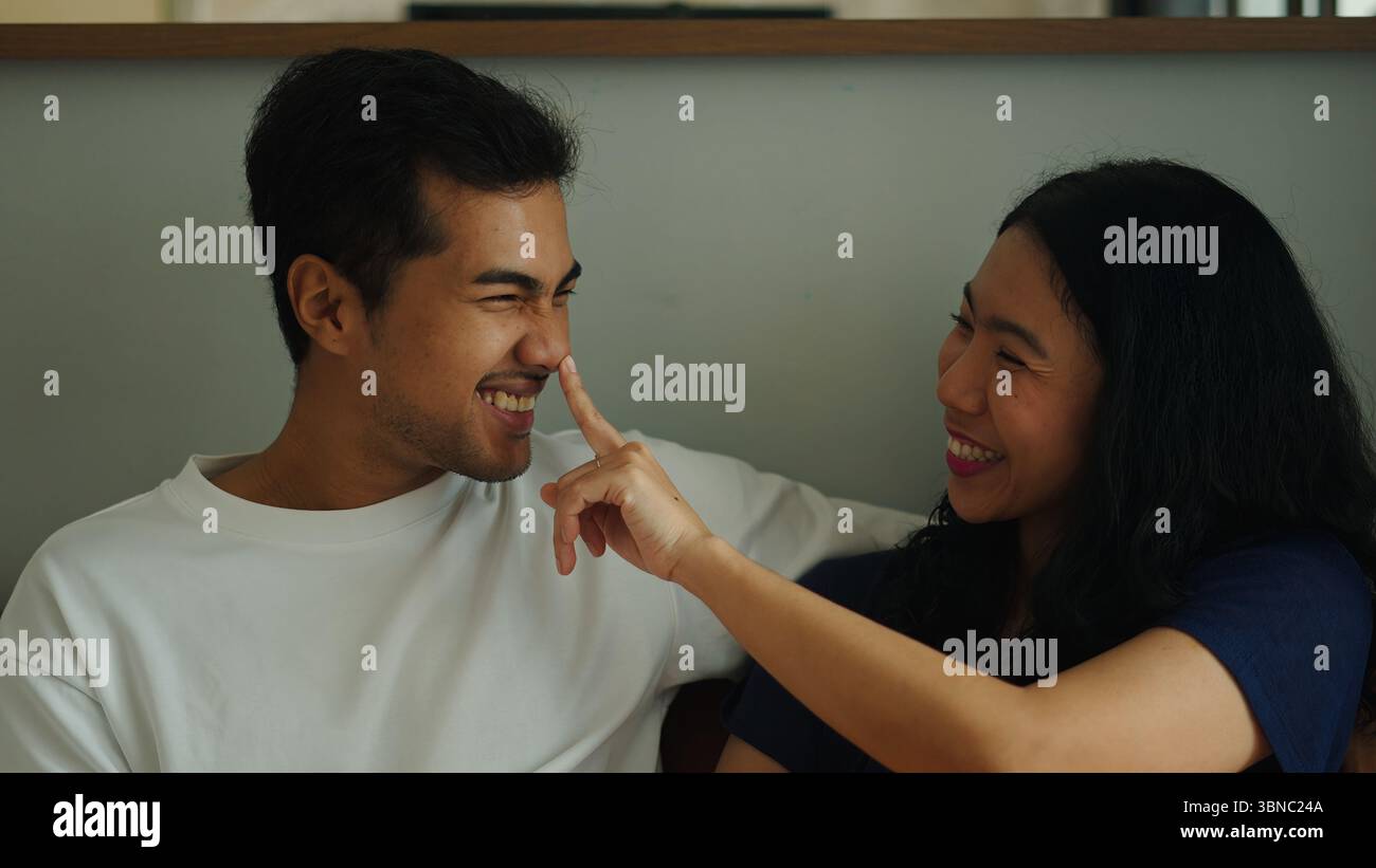 Romantic partners smiling, sharing playful connection during tender ...