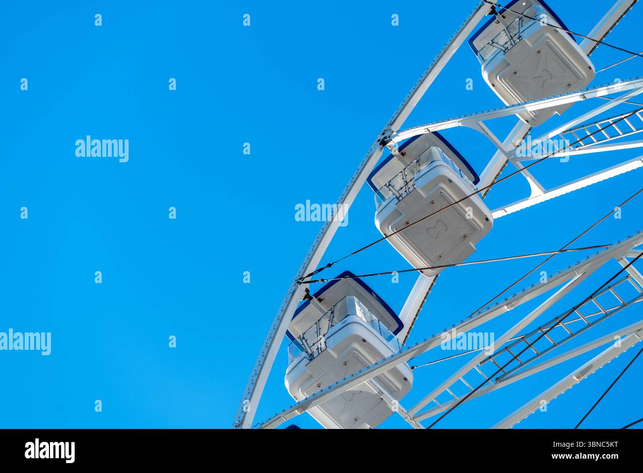 Brightly colored ferris wheel stands against a clear blue sky ...