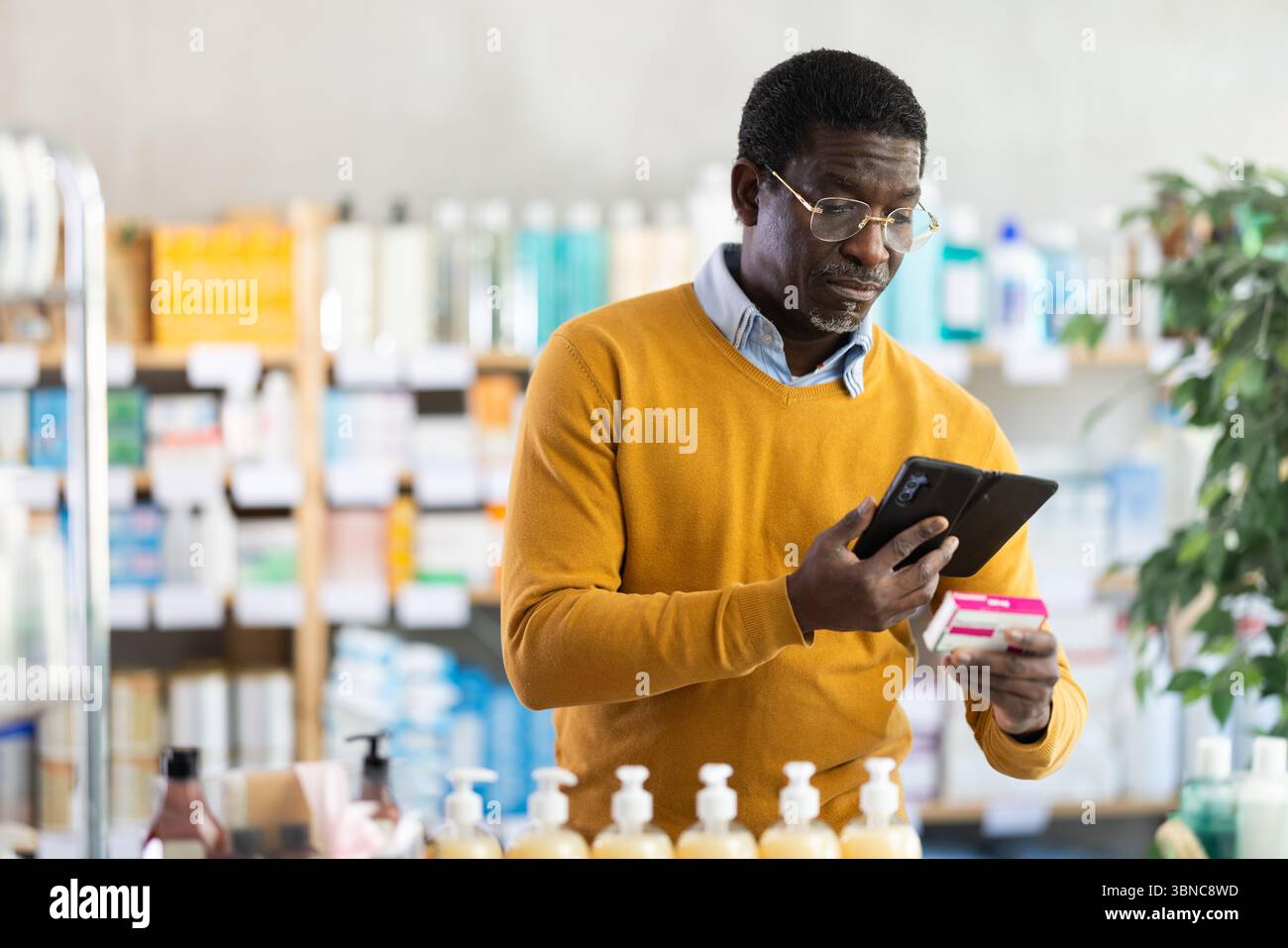 African American scanning barcode on paracetamol box with phone at ...
