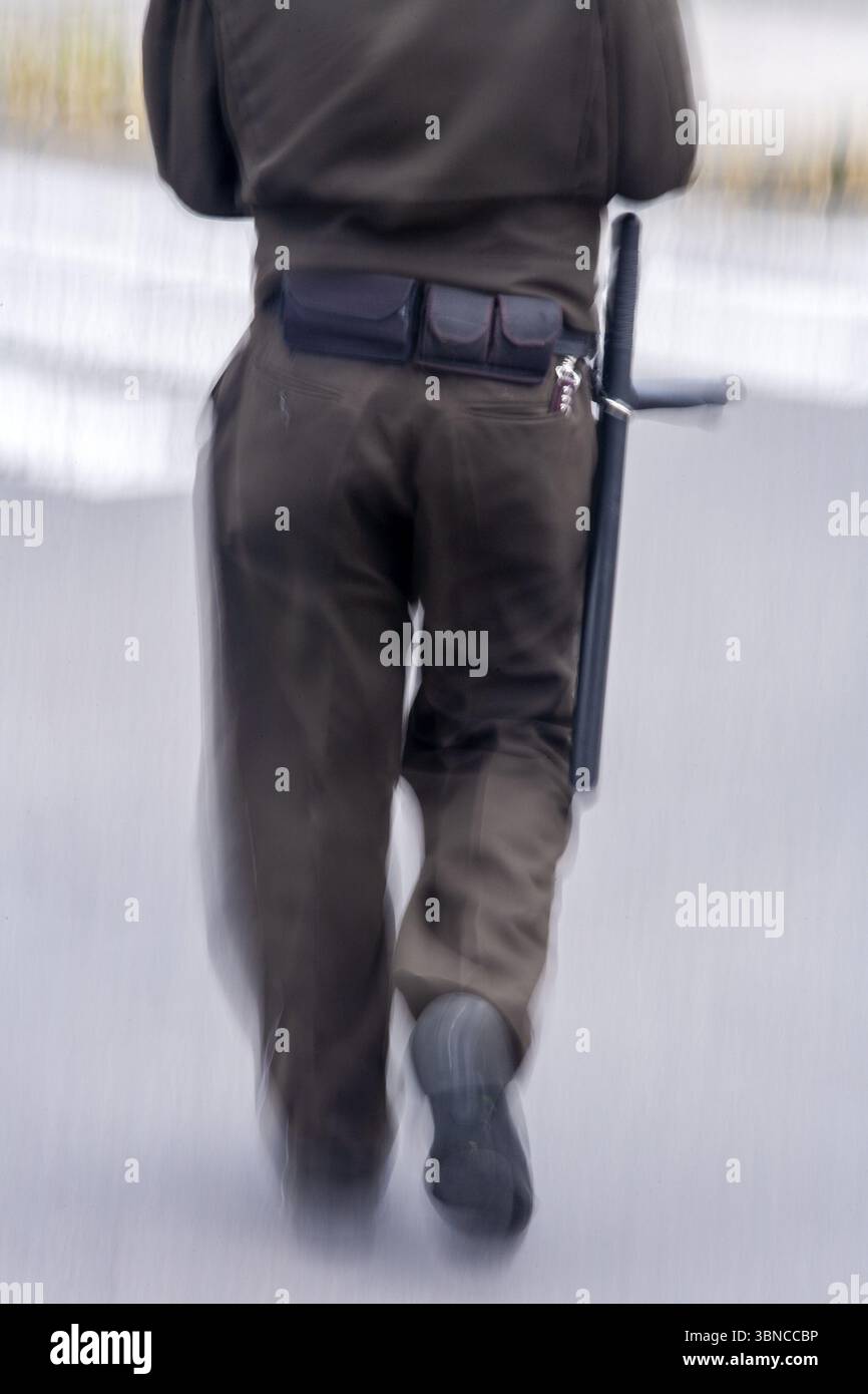 Policeman walking in the street, City of Quito. Pichincha province ...