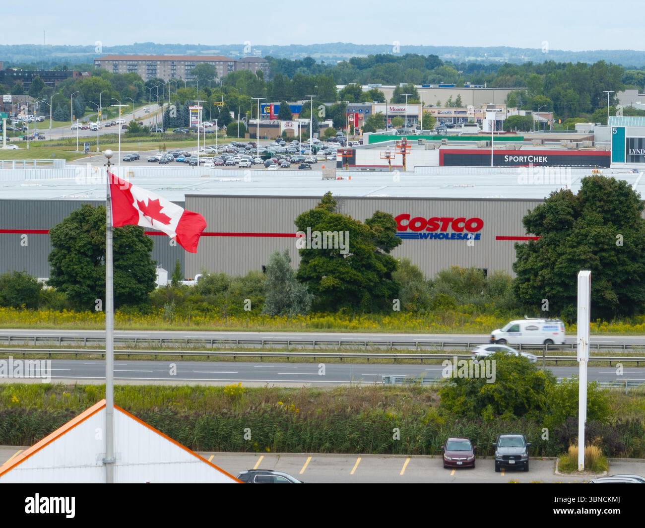 The Canadian flag waving in-front of a freeway, the Costco Wholesale ...