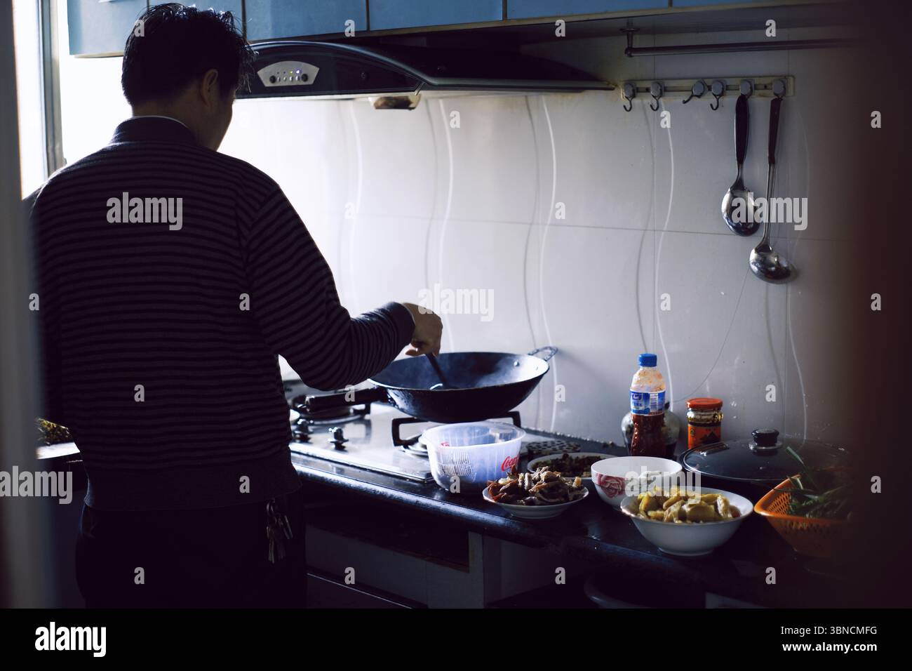Home Cook Stir-Frying in Wok at Kitchen Counter Stock Photo - Alamy