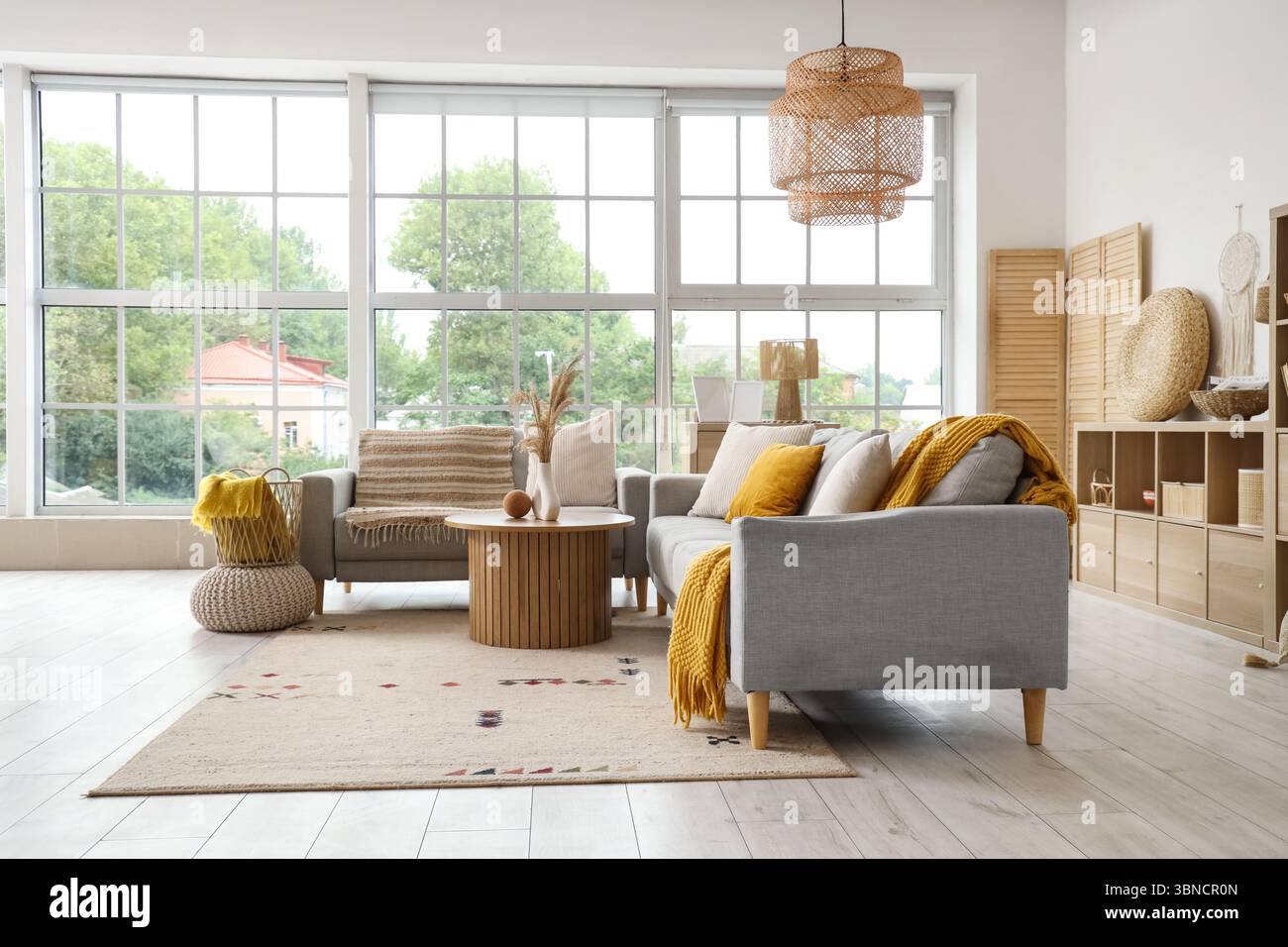 Interior of light living room with grey sofas and coffee table near ...