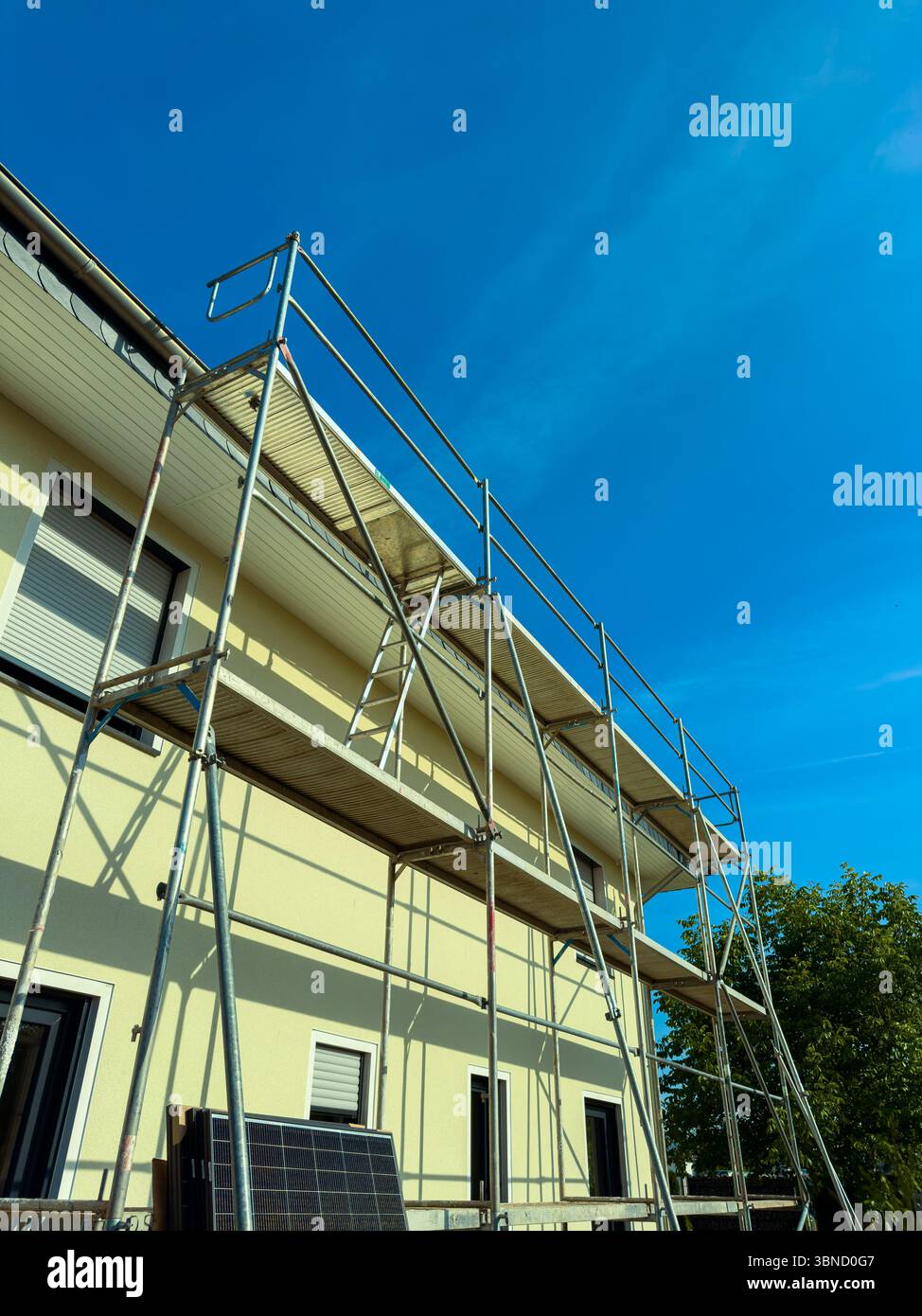 A sturdy scaffolding structure is positioned against a building, ready ...