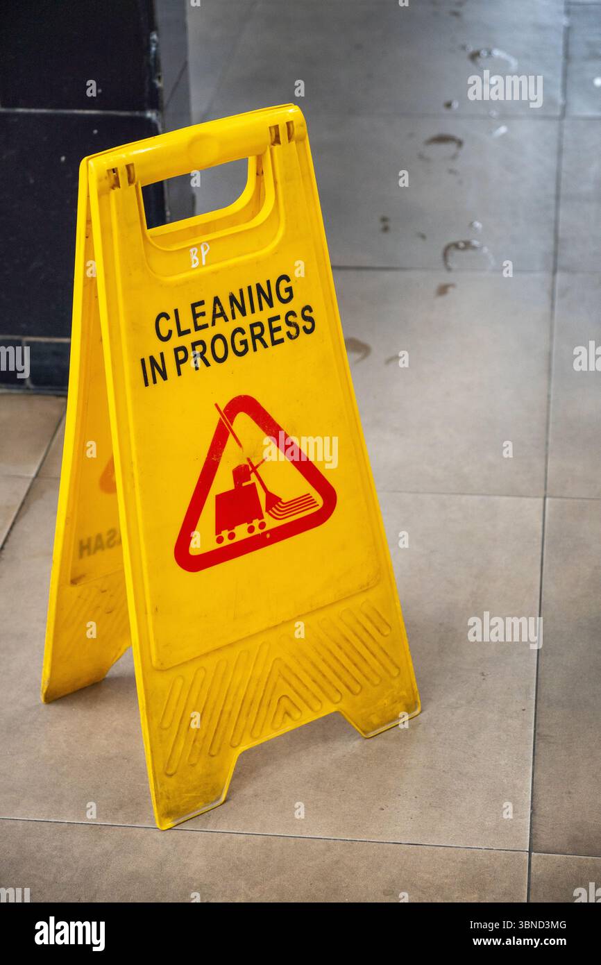 Yellow sign with a red triangle and the words "cleaning in progress" on ...