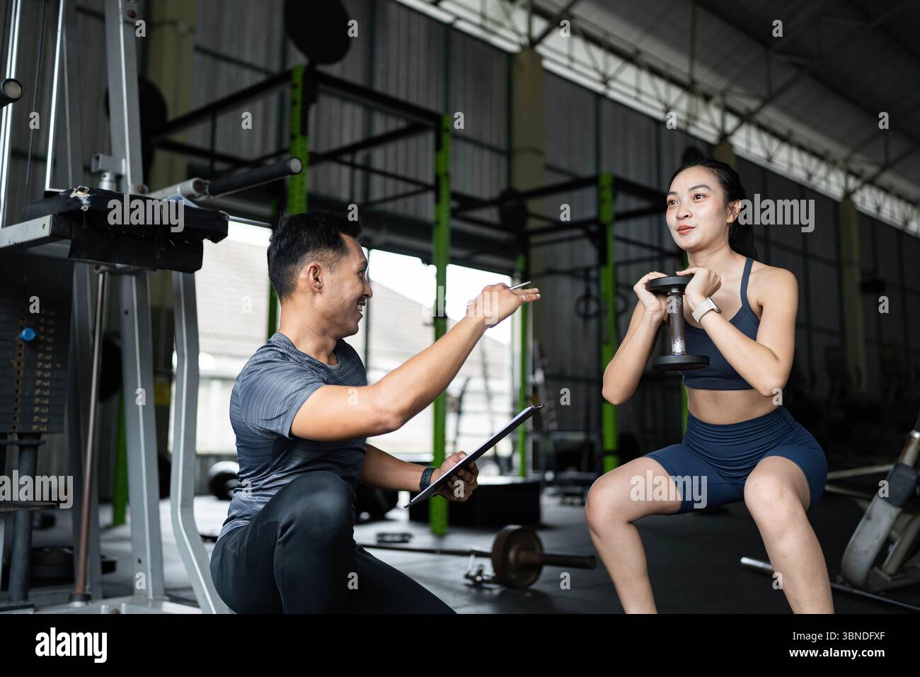 Fitness Coaching and Support. Personal trainer encouraging a young ...