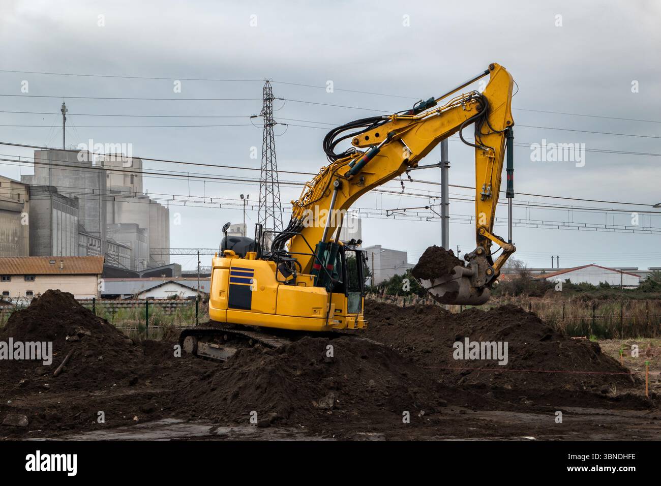 Backhoe loader leveling the ground to open the foundations for later ...