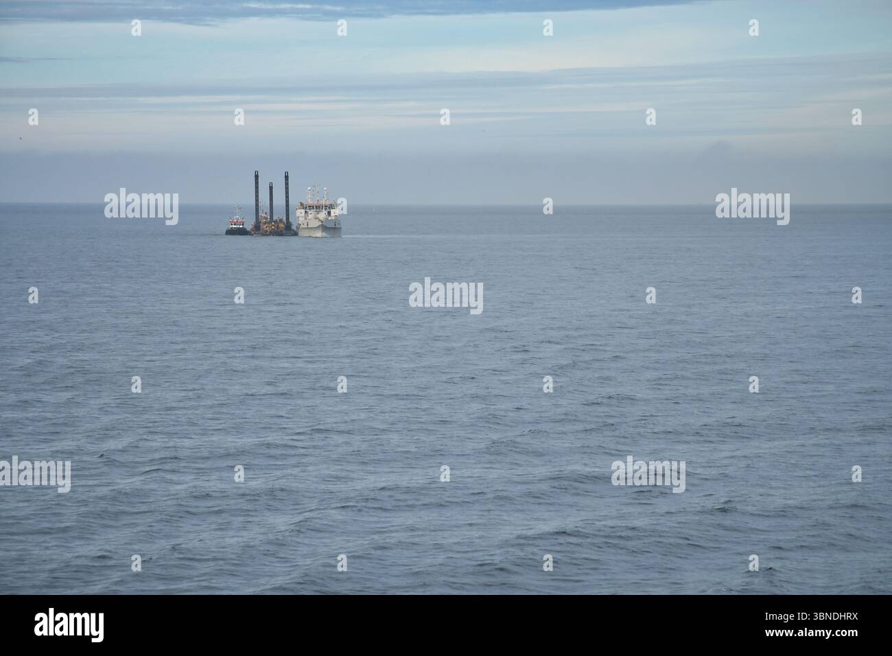 An offshore drilling platform in the open sea under a cloudy sky ...